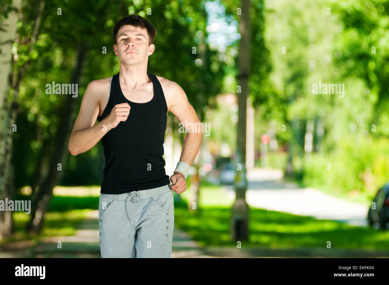 Young man jogging in park Stock Photo - Alamy
