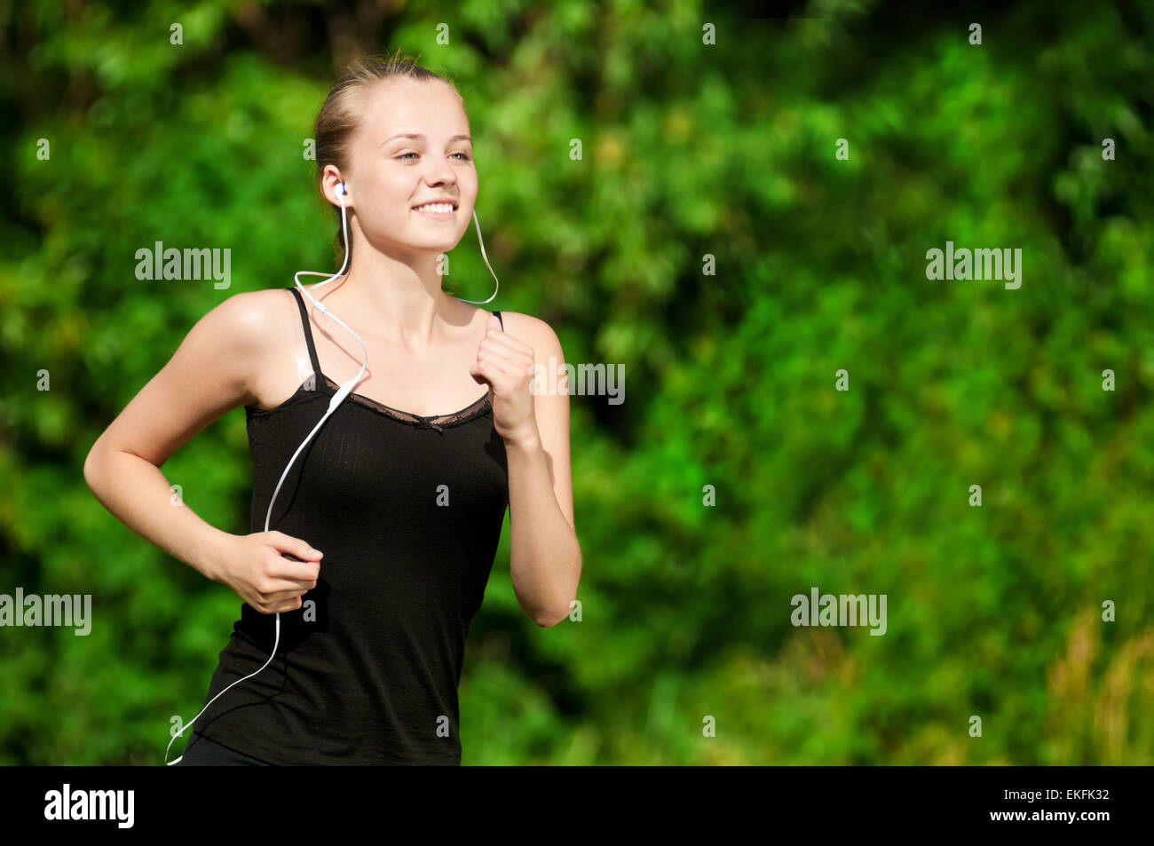 Young woman running in green park Stock Photo - Alamy
