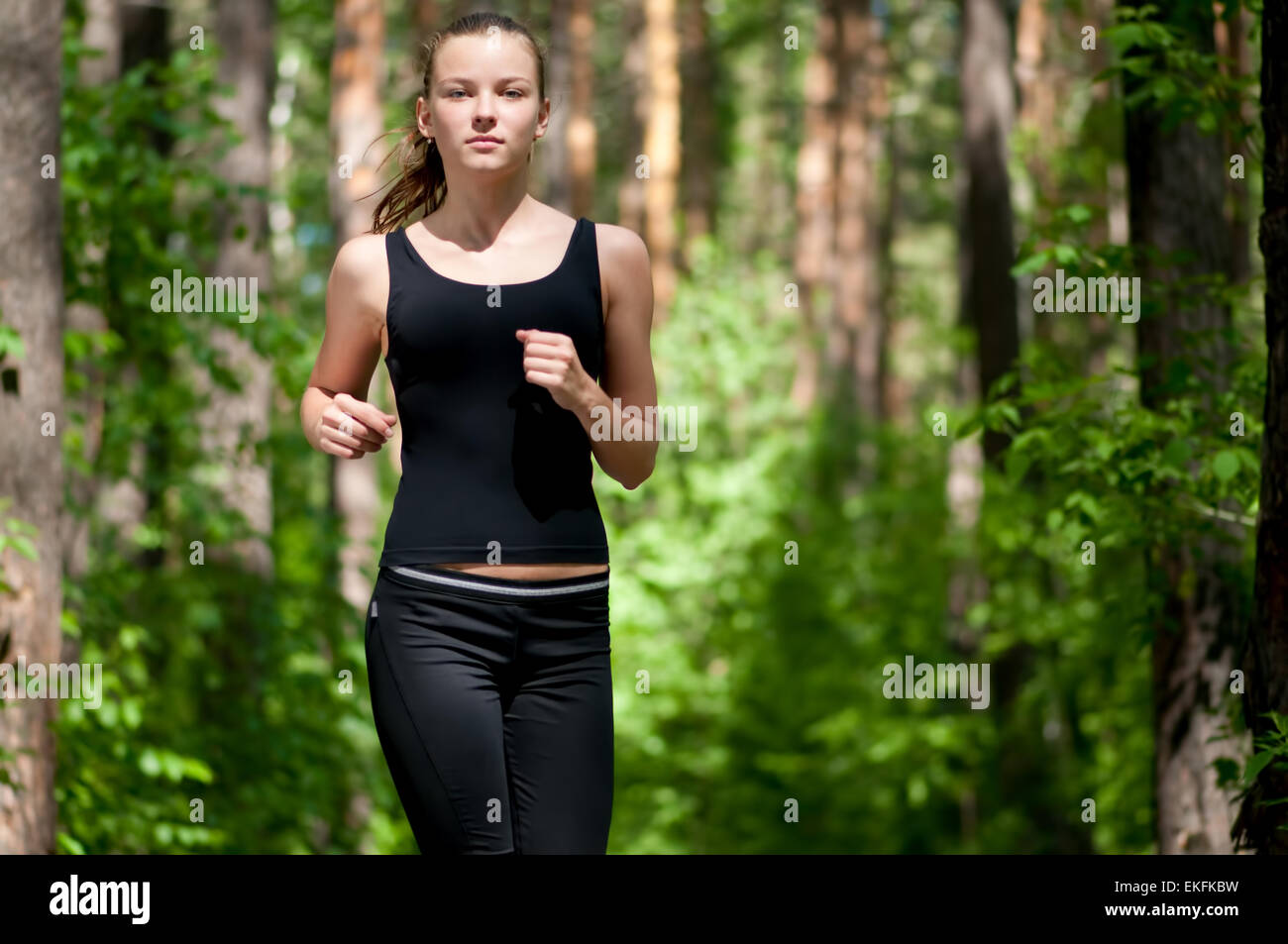 Beautiful woman running in green park Stock Photo - Alamy