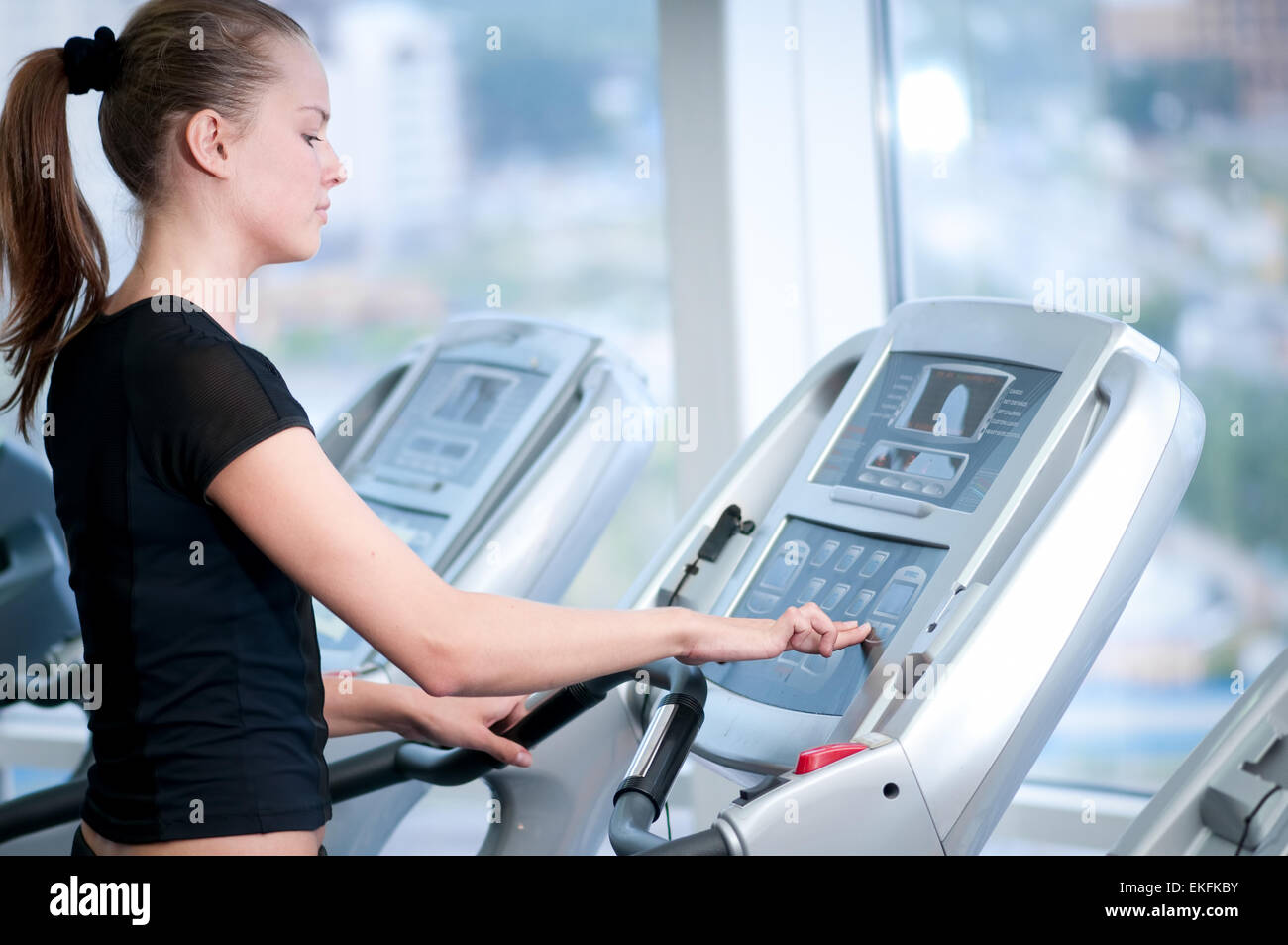 Young woman at the gym. Run on a machine Stock Photo - Alamy