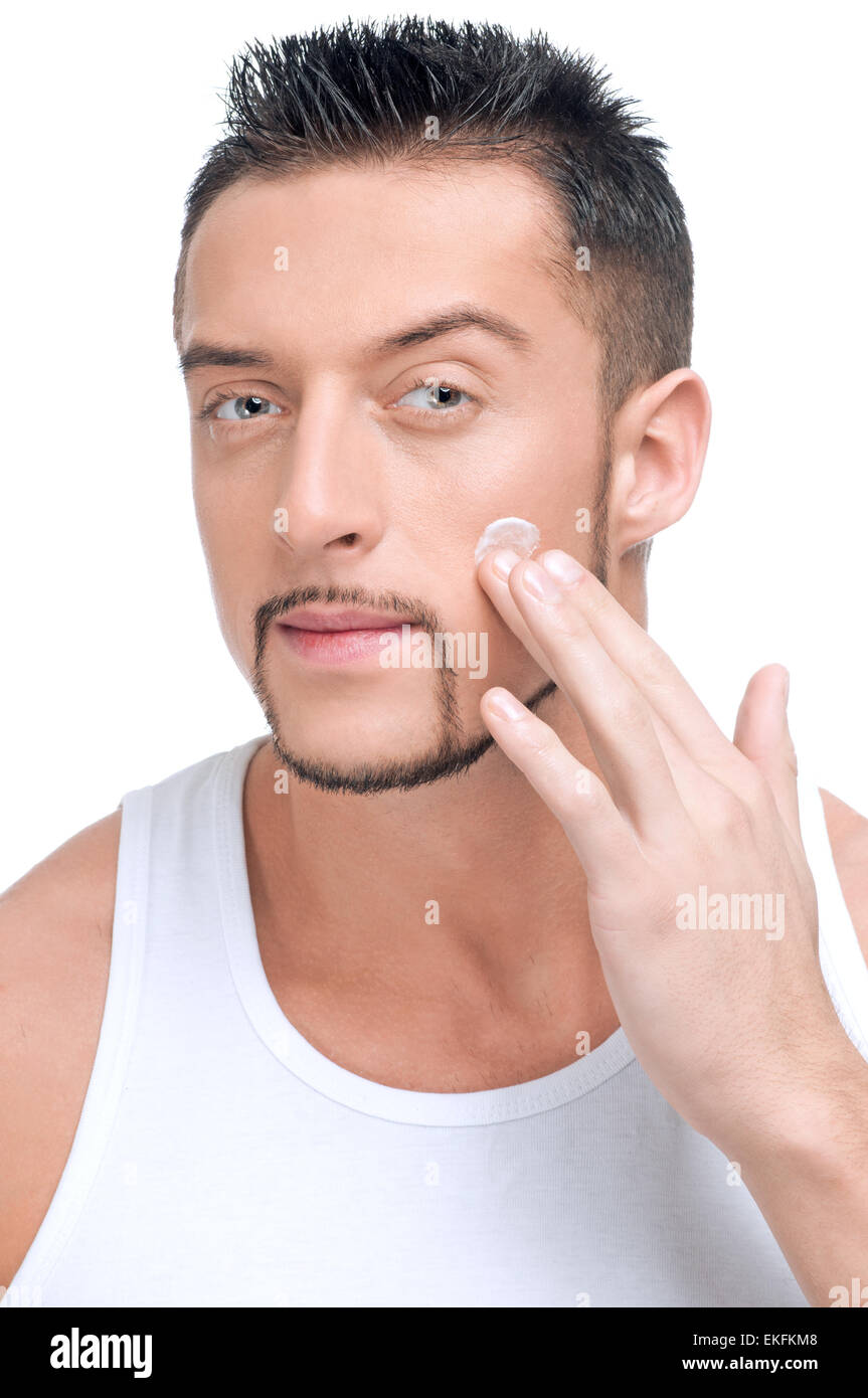 Handsome man applying male creme on face Stock Photo - Alamy