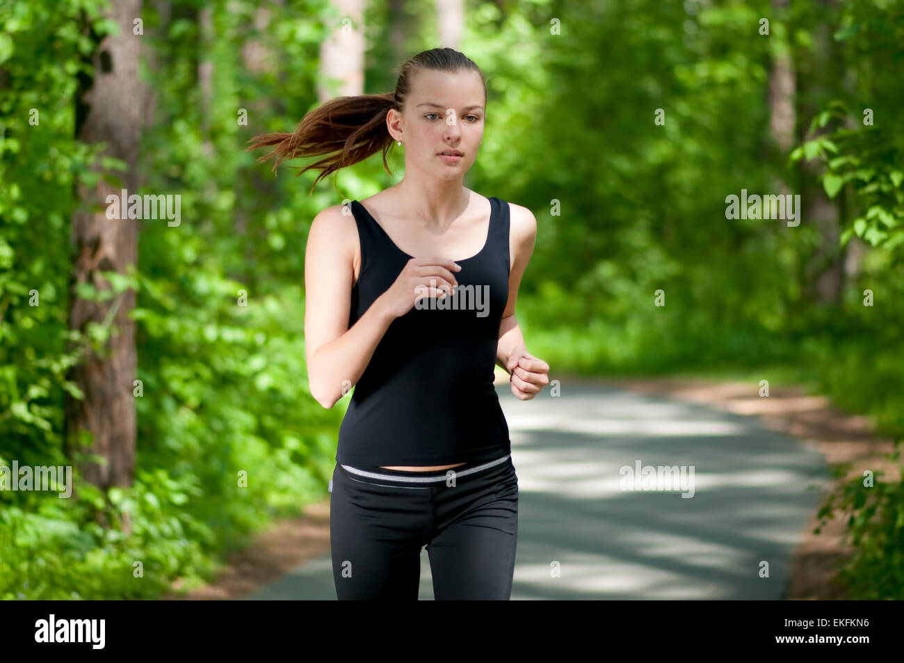 Beautiful woman running in green park Stock Photo - Alamy