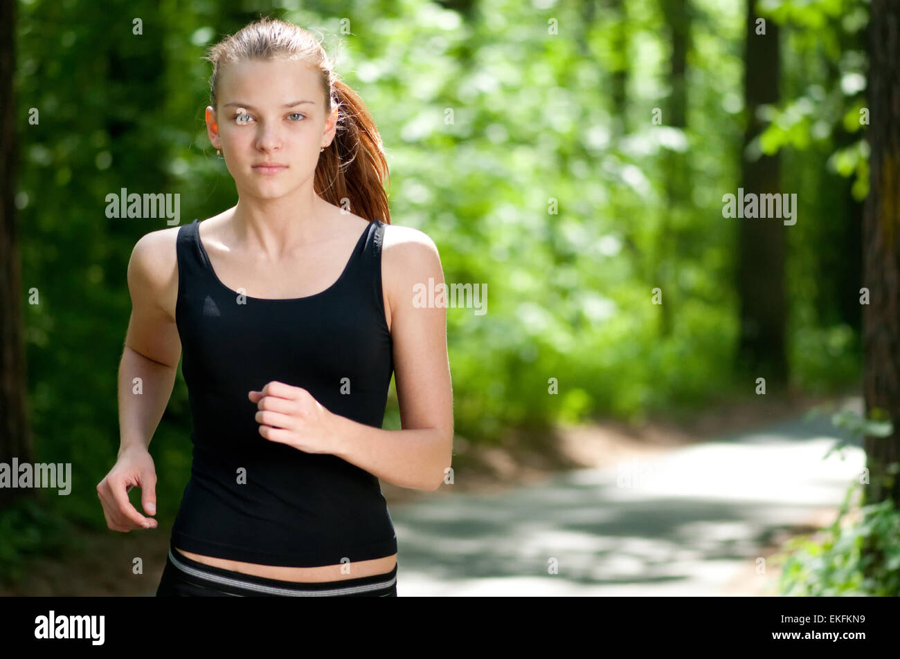 Beautiful woman running in green park Stock Photo - Alamy