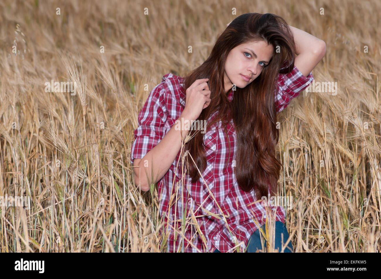 Beautiful cowboy woman posing in field Stock Photo - Alamy