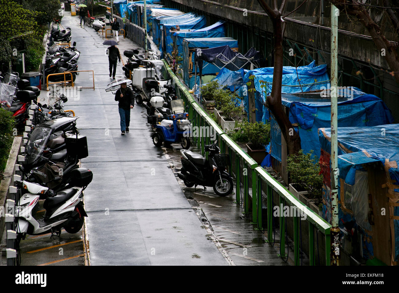 People walk next to the homeless camps in Miyashita Park on April 10 ...