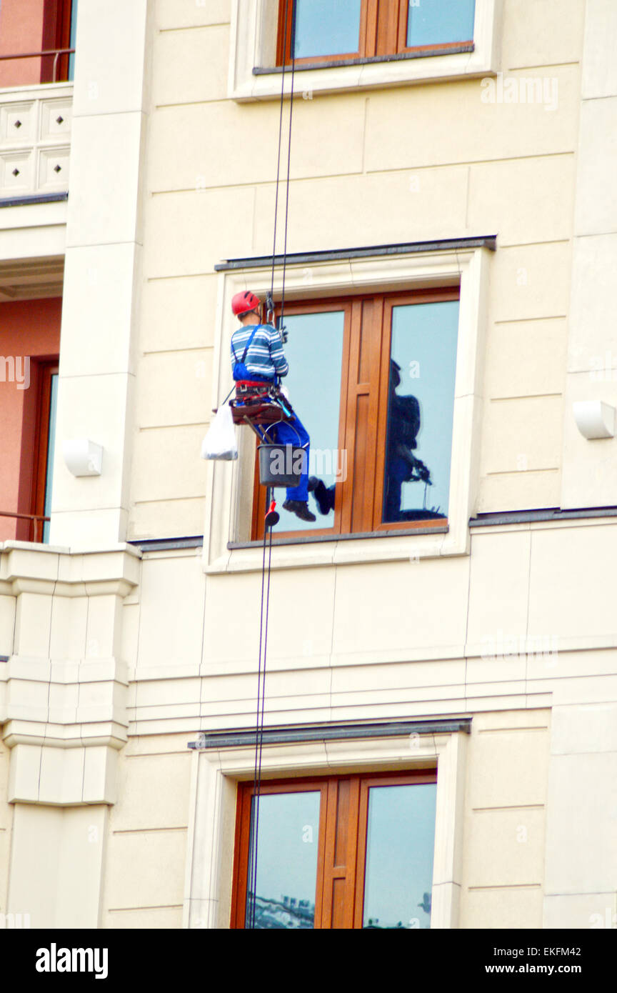 Man in special clothes washing windows on high-rise building Stock ...