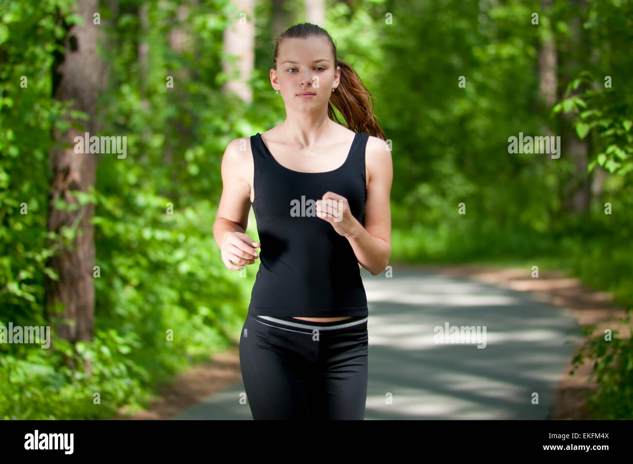 Beautiful woman running in green park Stock Photo - Alamy