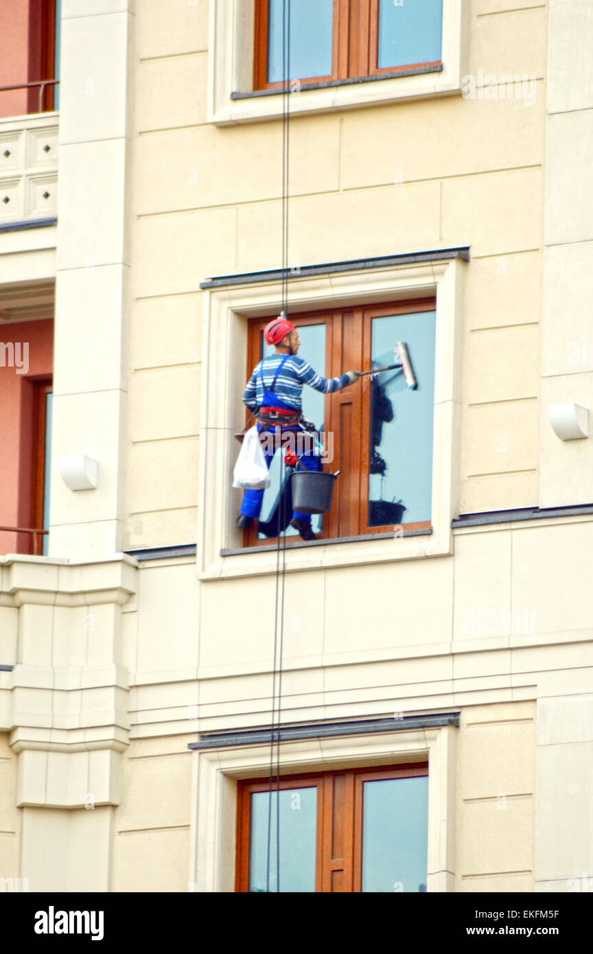 Man in special clothes washing windows on high-rise building Stock ...