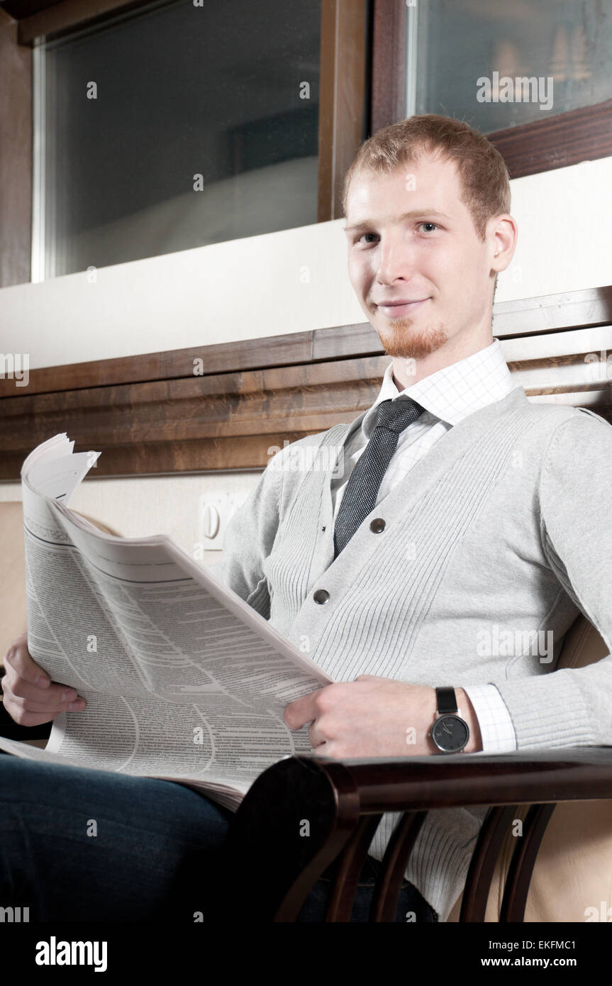 Sure young business man with newspaper Stock Photo - Alamy