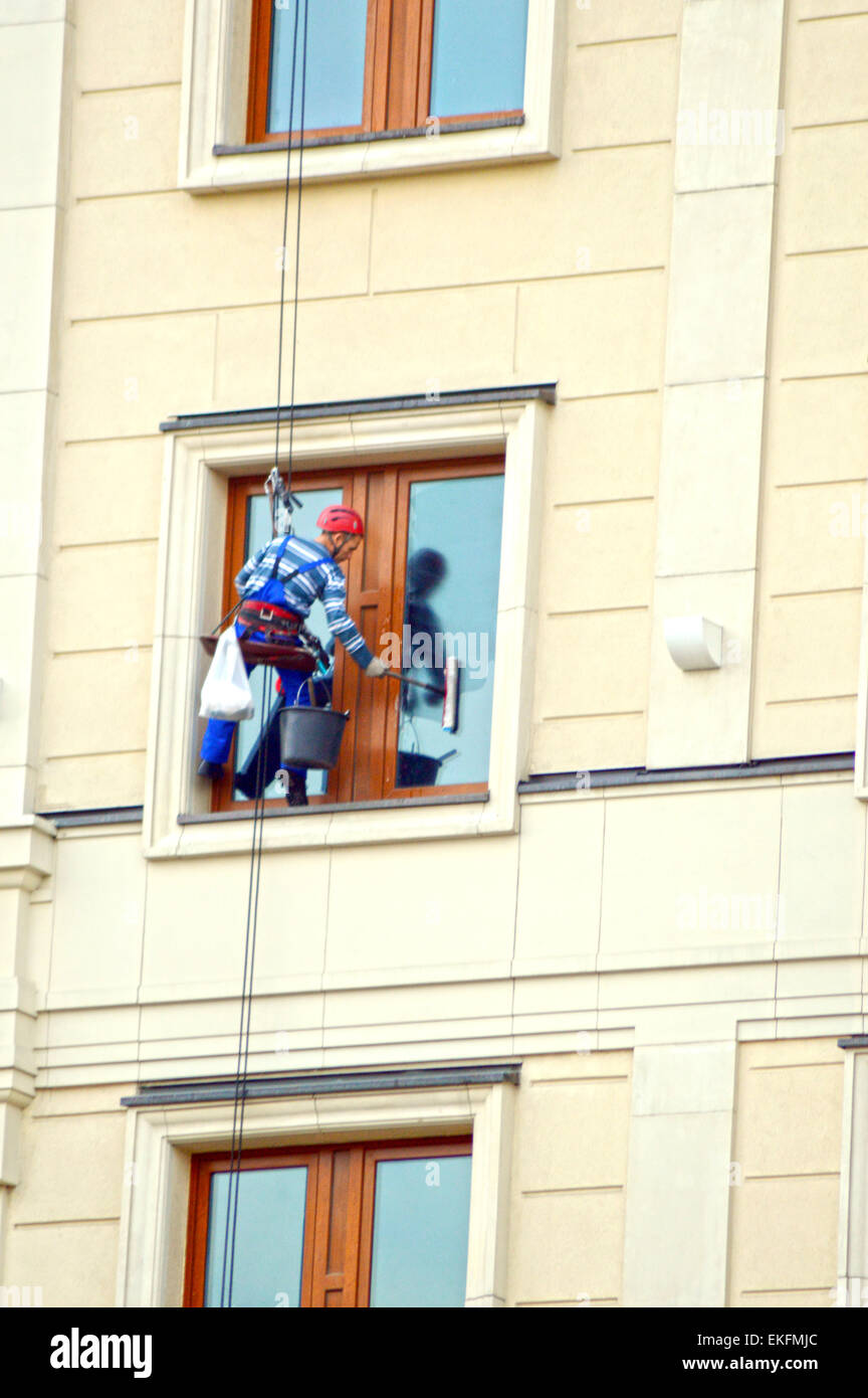 Man in special clothes washing windows on high-rise building Stock ...