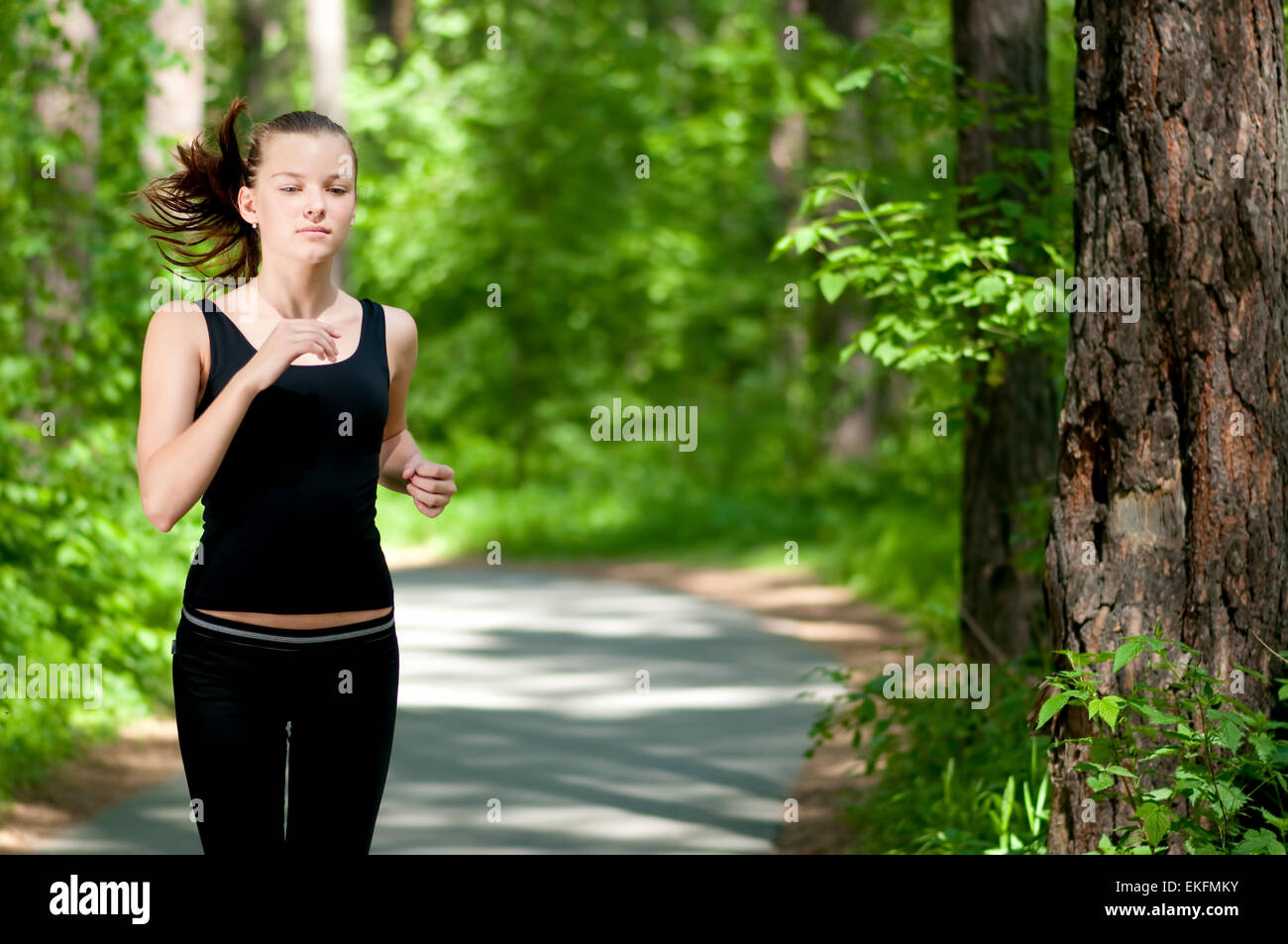 Beautiful woman running in green park Stock Photo - Alamy