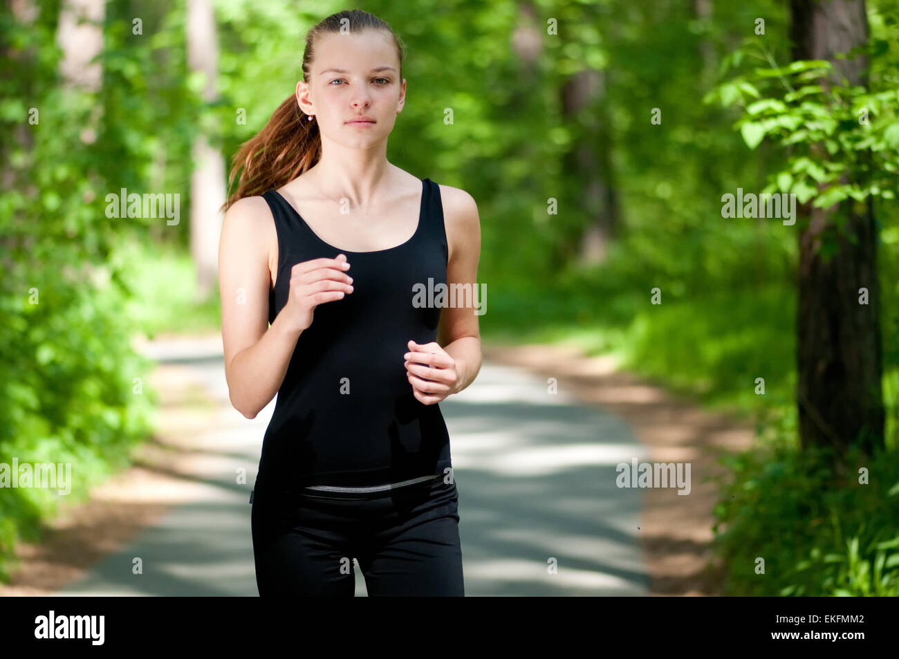 Beautiful woman running in green park Stock Photo - Alamy