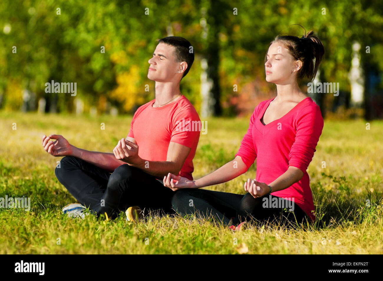 Man and woman woman doing yoga in park Stock Photo - Alamy