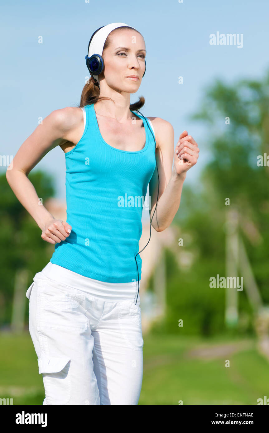 Beautiful woman running in green park Stock Photo - Alamy