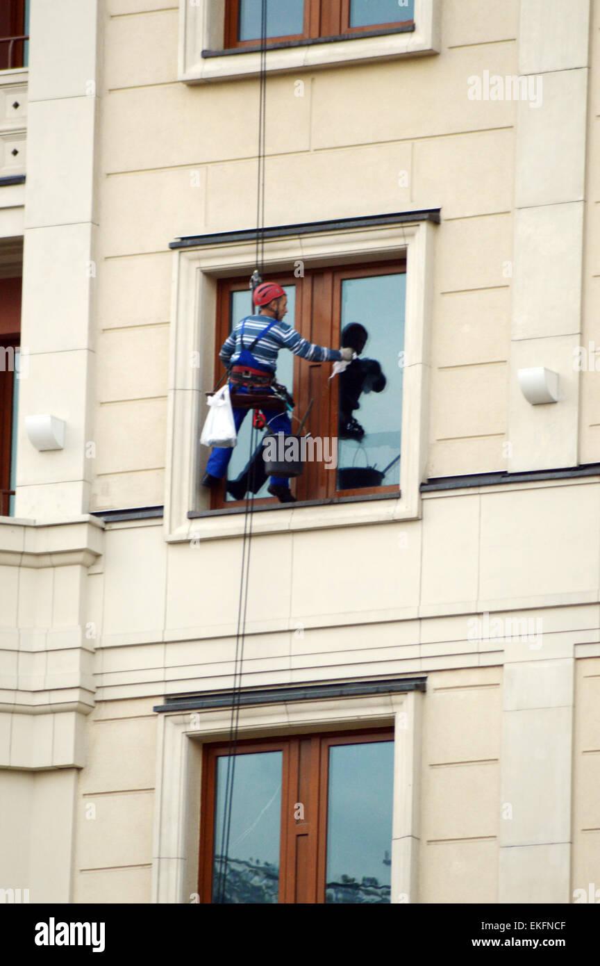 Man in special clothes washing windows on high-rise building Stock ...