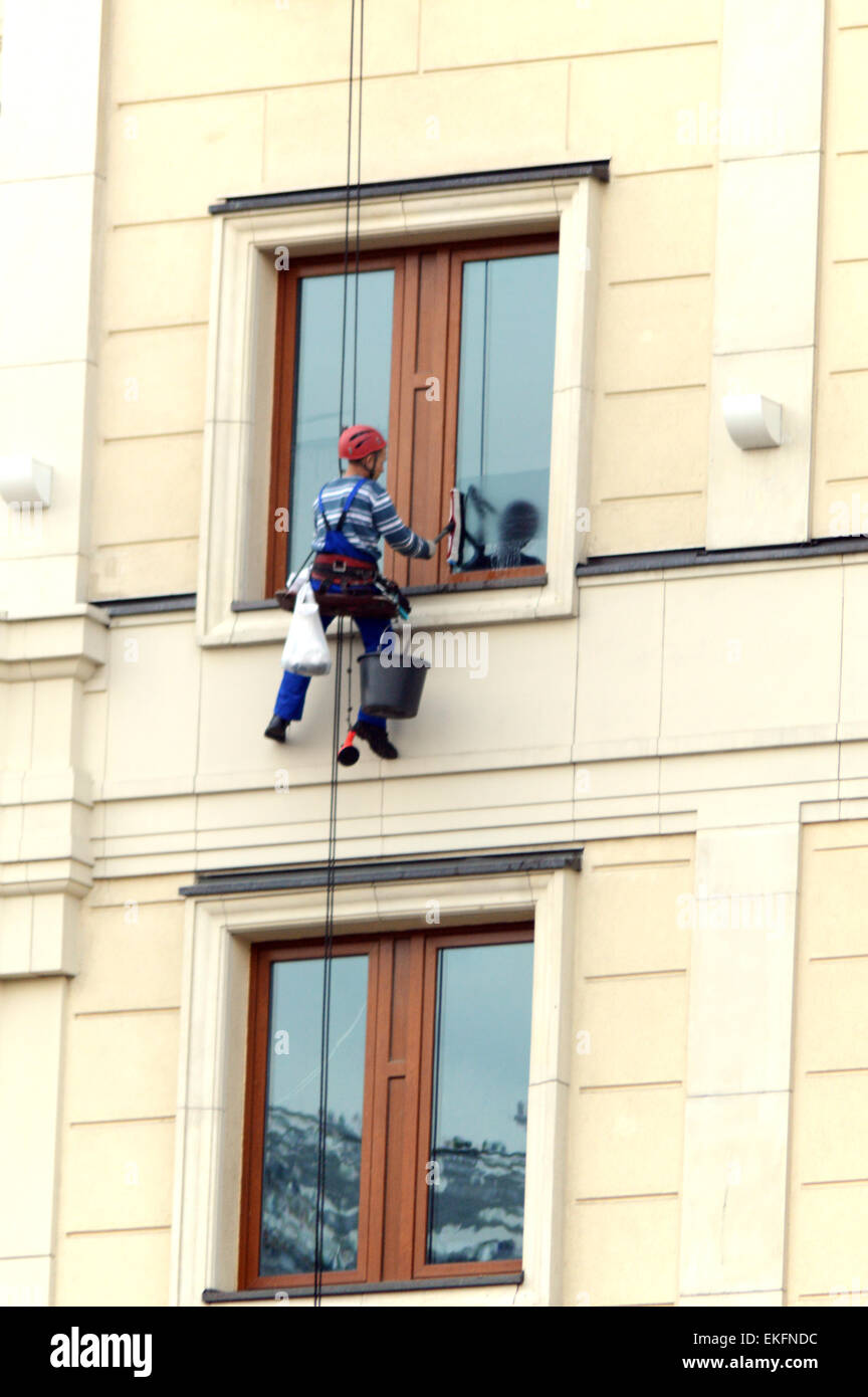 Man in special clothes washing windows on high-rise building Stock ...