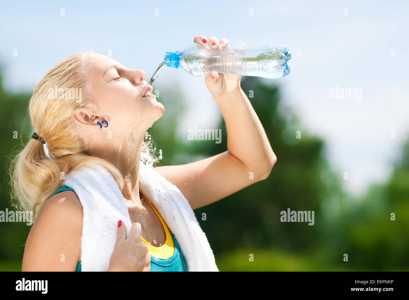 Woman drinking water after exercise Stock Photo - Alamy