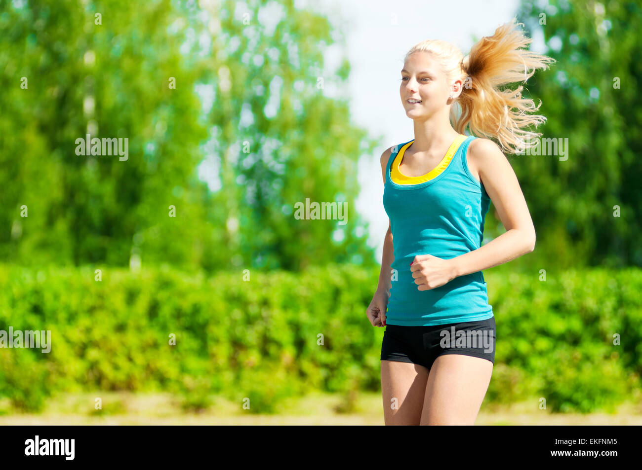 Young woman running in green park Stock Photo - Alamy