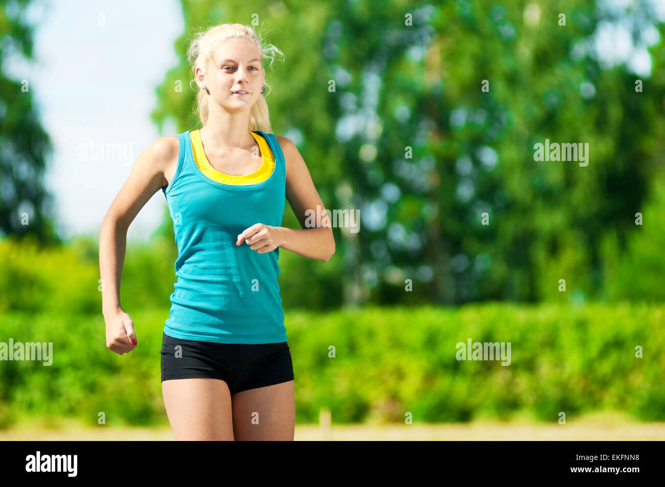 Young woman running in green park Stock Photo - Alamy