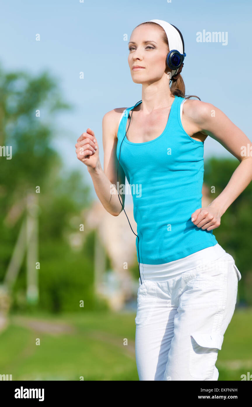 Beautiful woman running in green park Stock Photo - Alamy