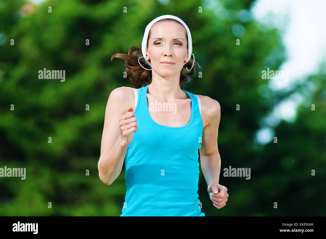 Beautiful woman running in green park Stock Photo - Alamy