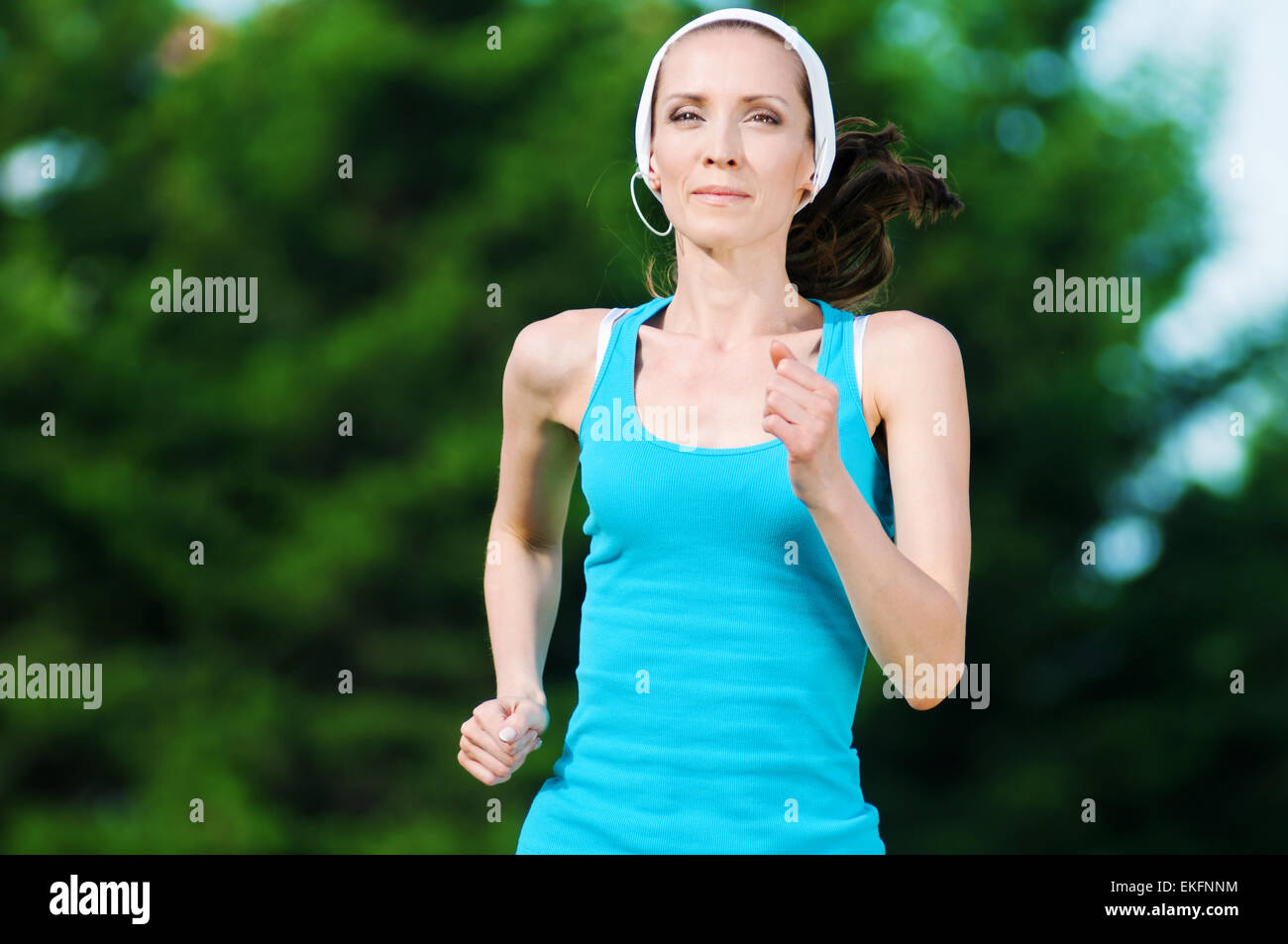 Beautiful woman running in green park Stock Photo - Alamy