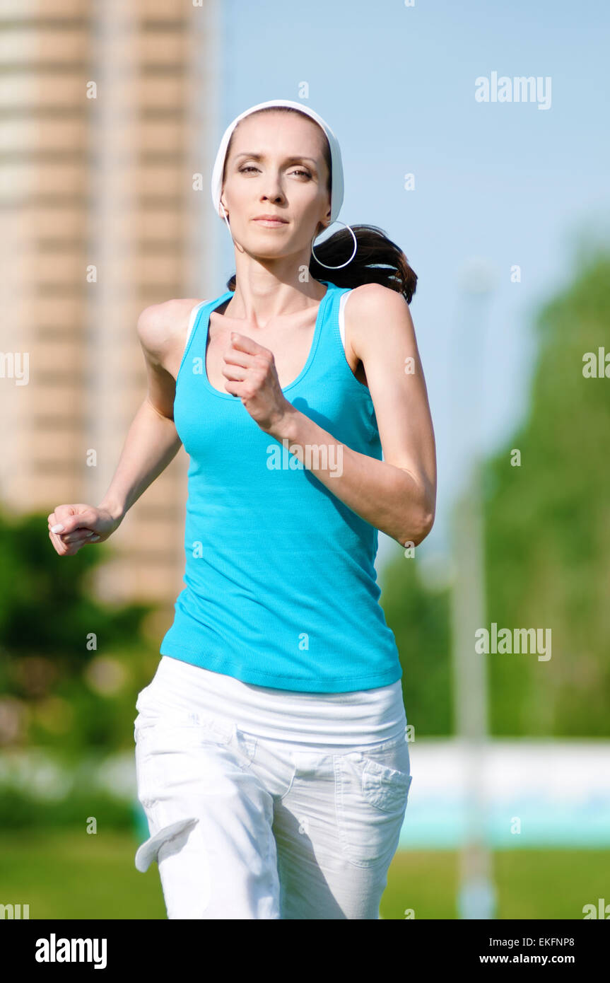 Beautiful woman running in green park Stock Photo - Alamy