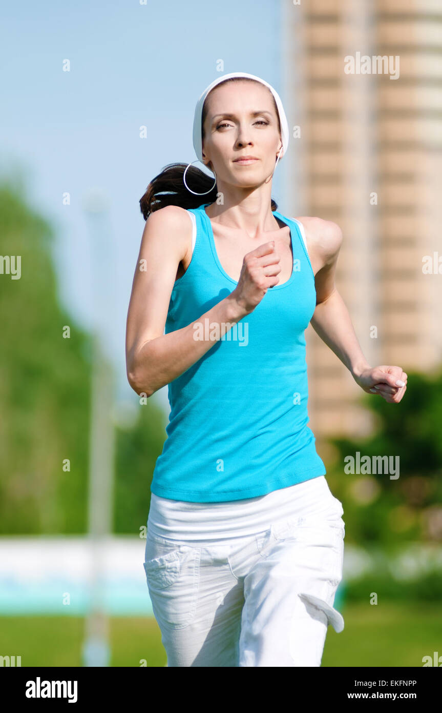 Beautiful woman running in green park Stock Photo - Alamy