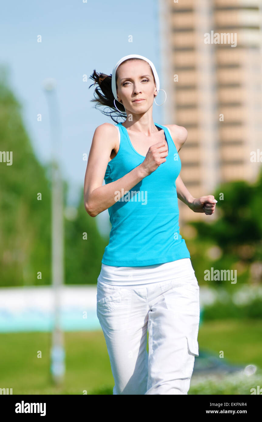 Beautiful woman running in green park Stock Photo - Alamy