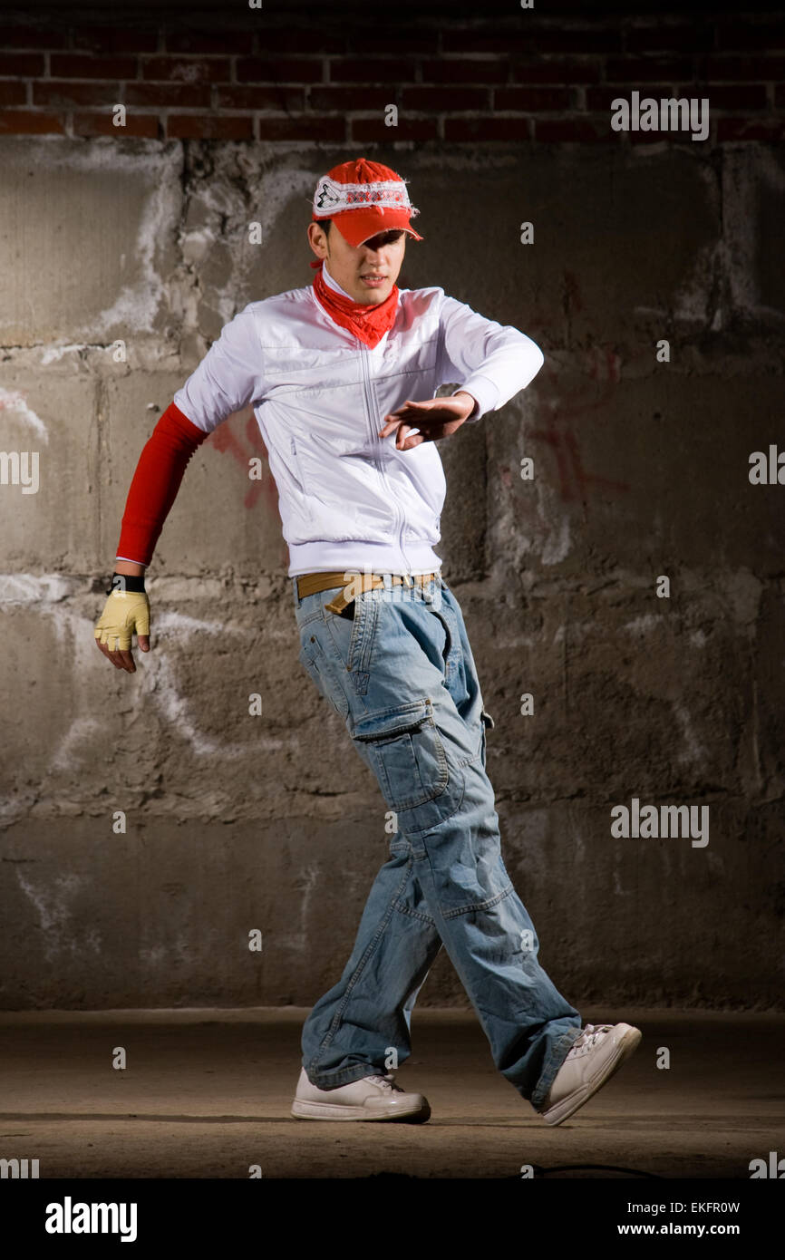 Hip hop boy dancing in modern style over grey brick wall Stock Photo ...
