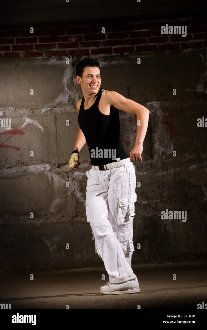 Hip hop boy dancing in modern style over grey brick wall Stock Photo ...