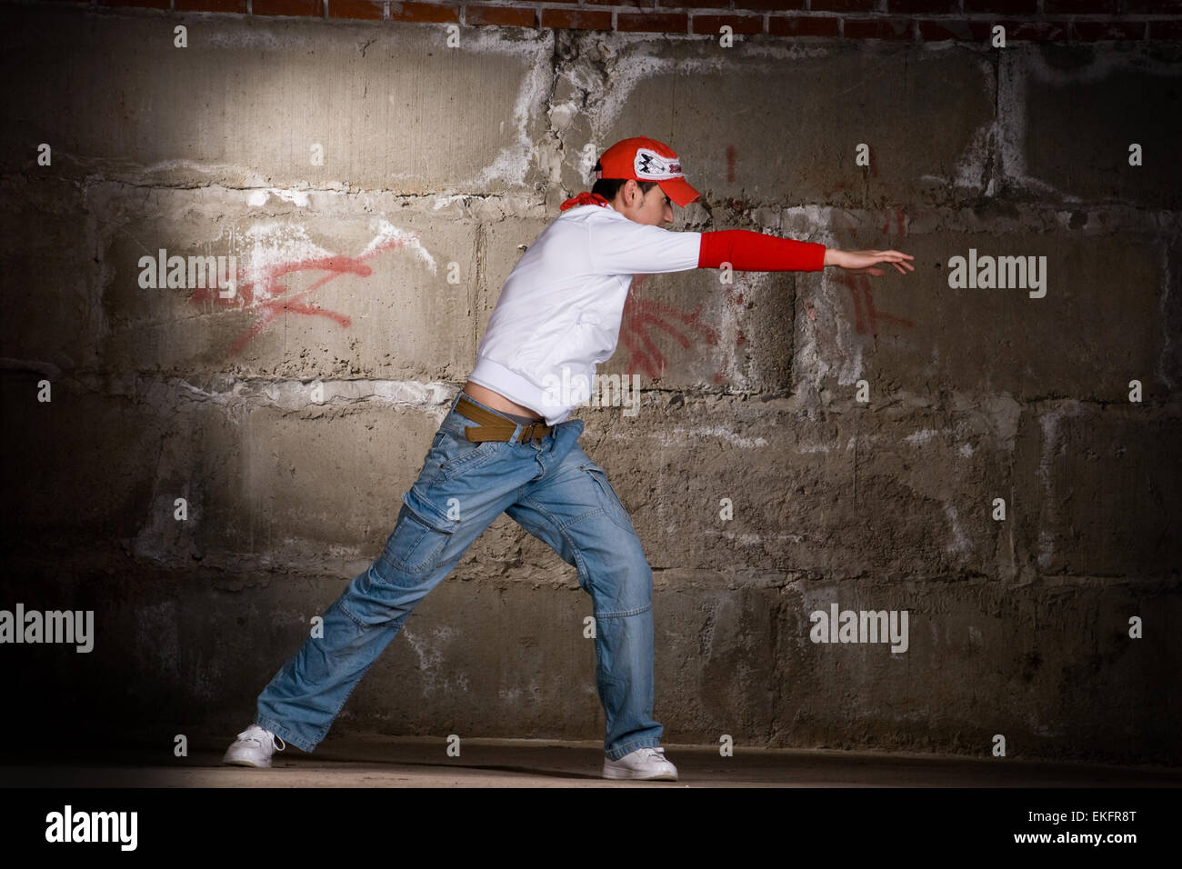 Hip hop boy dancing in modern style over grey brick wall Stock Photo ...
