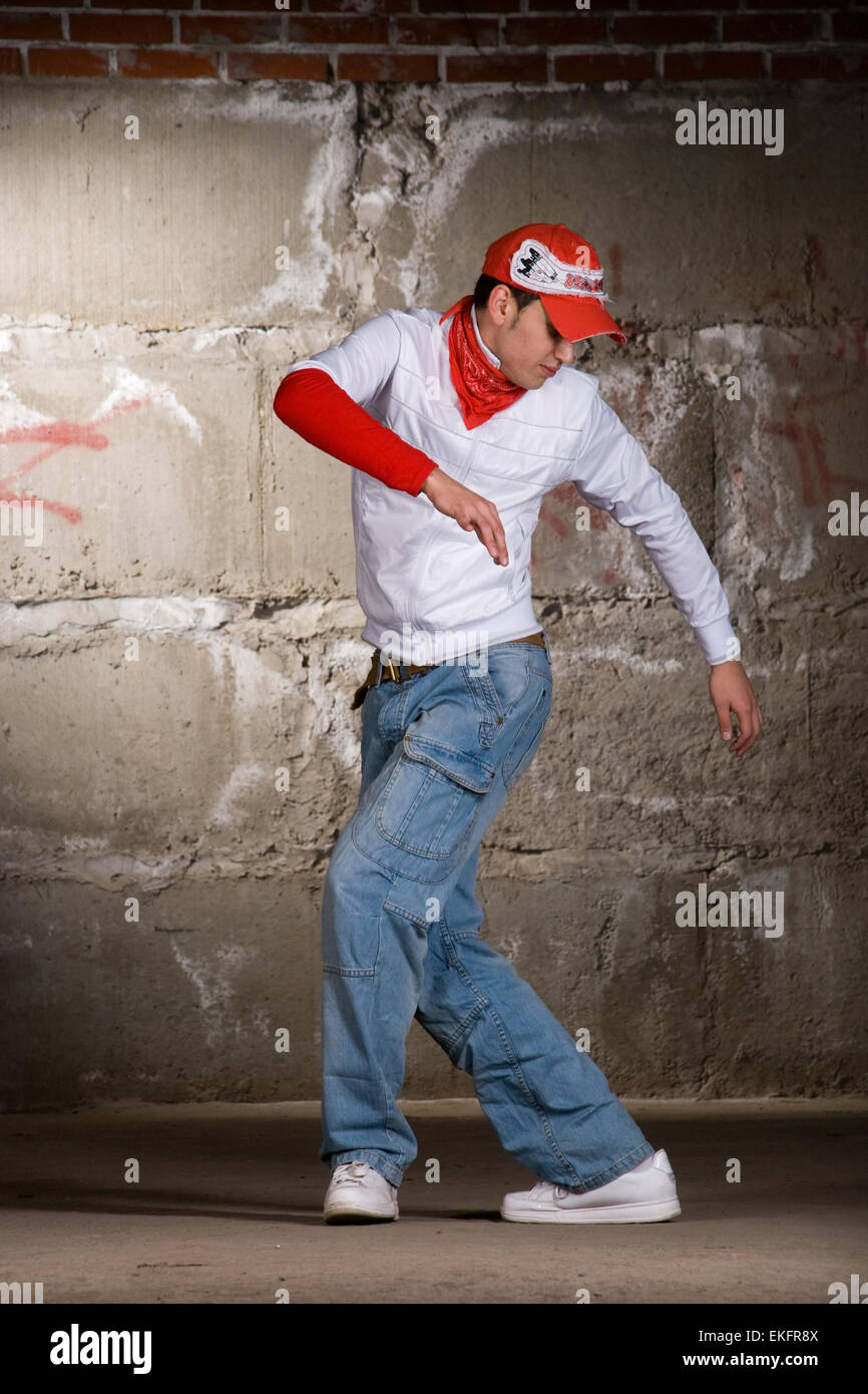 Hip hop boy dancing in modern style over grey brick wall Stock Photo ...
