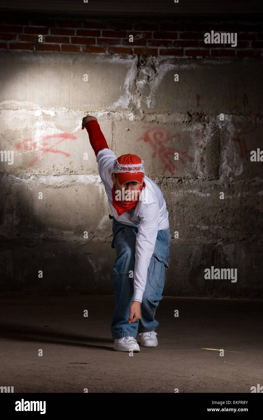 Hip hop boy dancing in modern style over grey brick wall Stock Photo ...