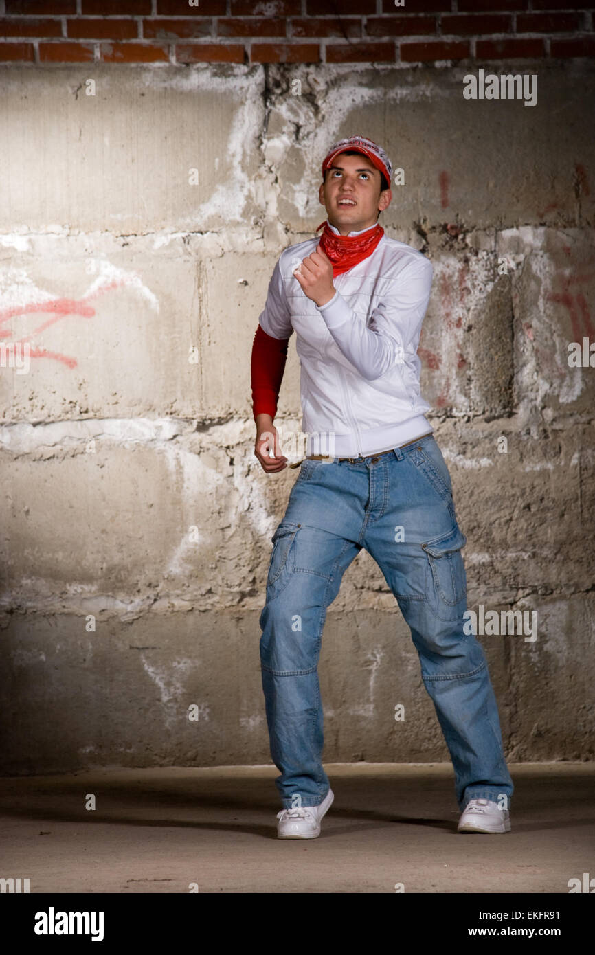 Hip hop boy dancing in modern style over grey brick wall Stock Photo ...