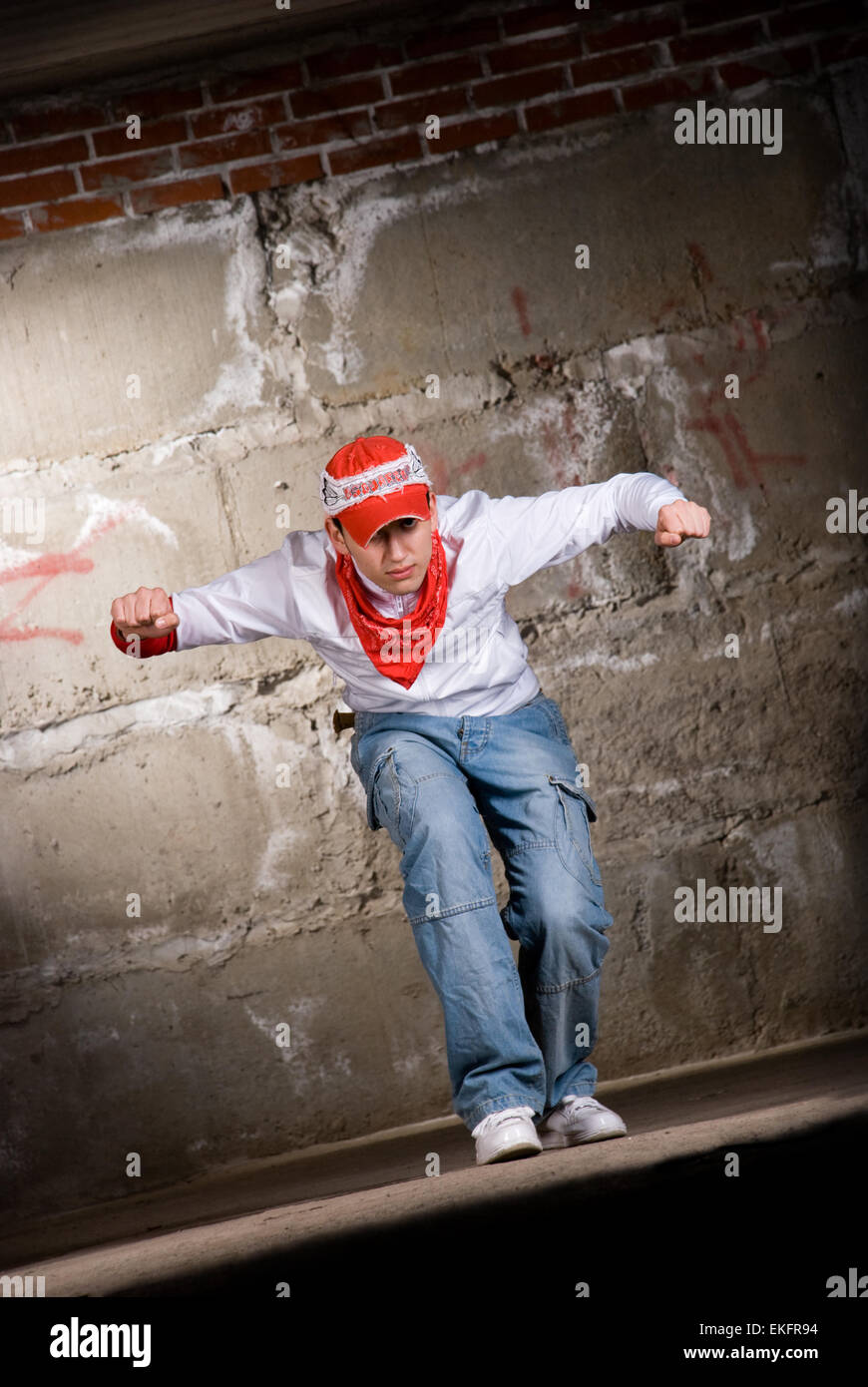Hip hop boy dancing in modern style over grey brick wall Stock Photo ...