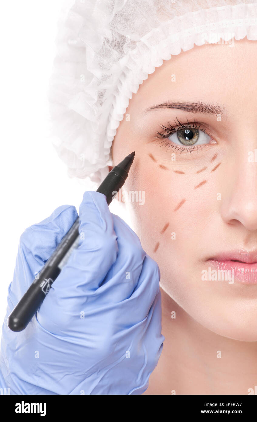 Beautician draw correction lines on woman face Stock Photo - Alamy