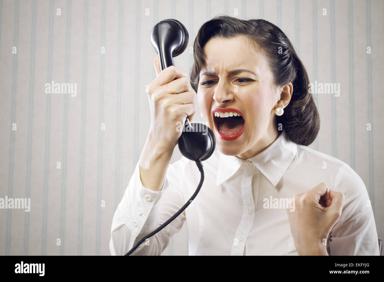 Young Woman shouting into telephone Stock Photo - Alamy