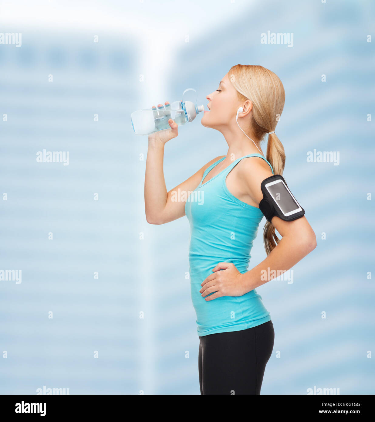 sporty woman running with smartphone and earphones Stock Photo - Alamy