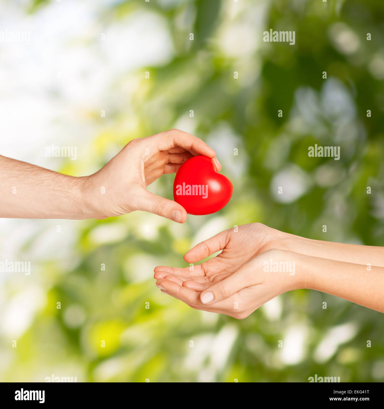 man hand giving red heart to woman Stock Photo - Alamy