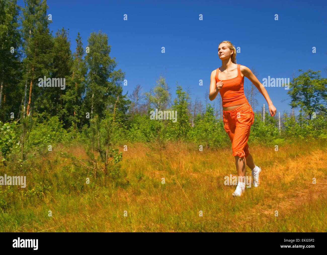 Beautiful girl running in the forest Stock Photo - Alamy