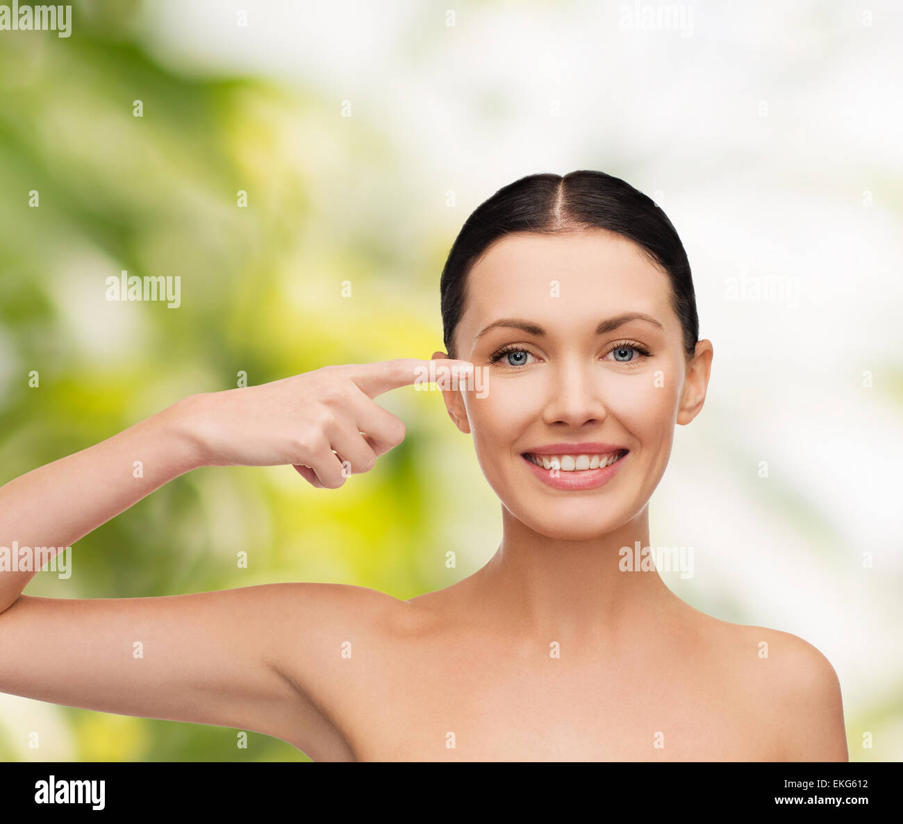 young calm woman pointing to her eye Stock Photo - Alamy