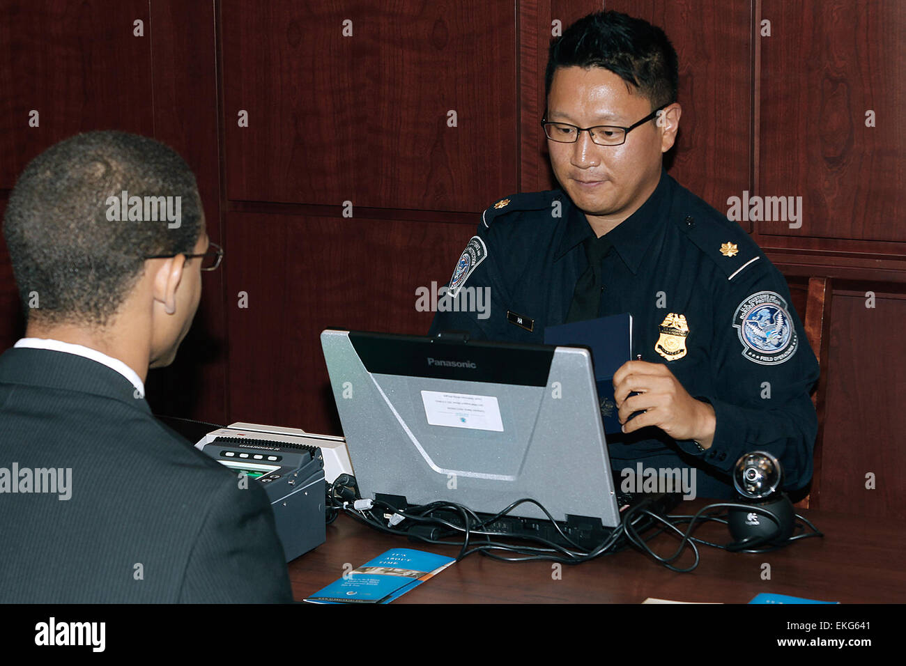 A CBP officer in Washington, DC, captures biometric data, including ...