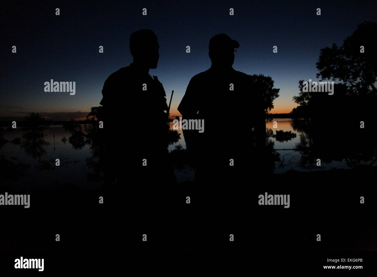 A U.S. Border Patrol agent and a CBP officer monitor the Missouri River ...