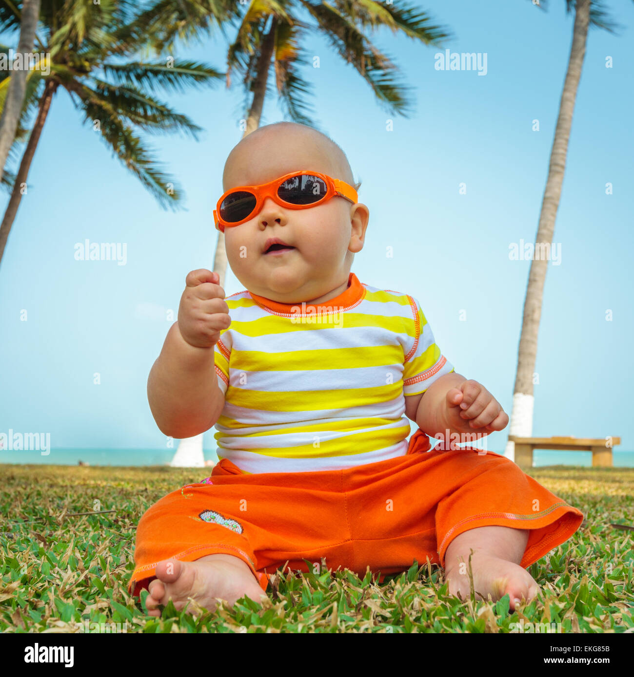Cute baby sitting on a grass Stock Photo - Alamy