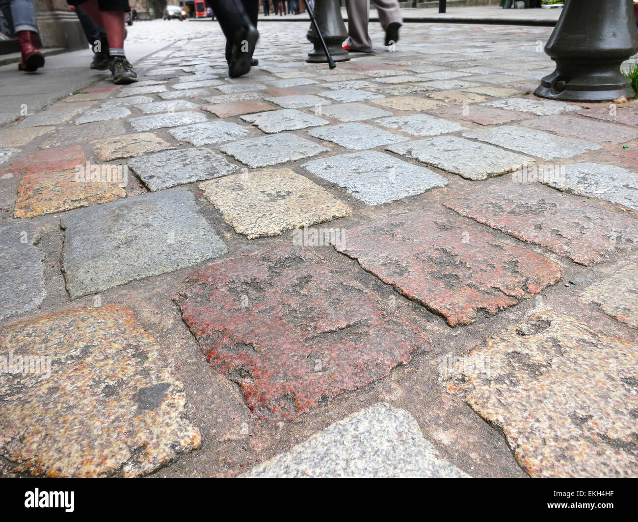 Old tiles, pavement and feet of pedestrians walking in the old city ...