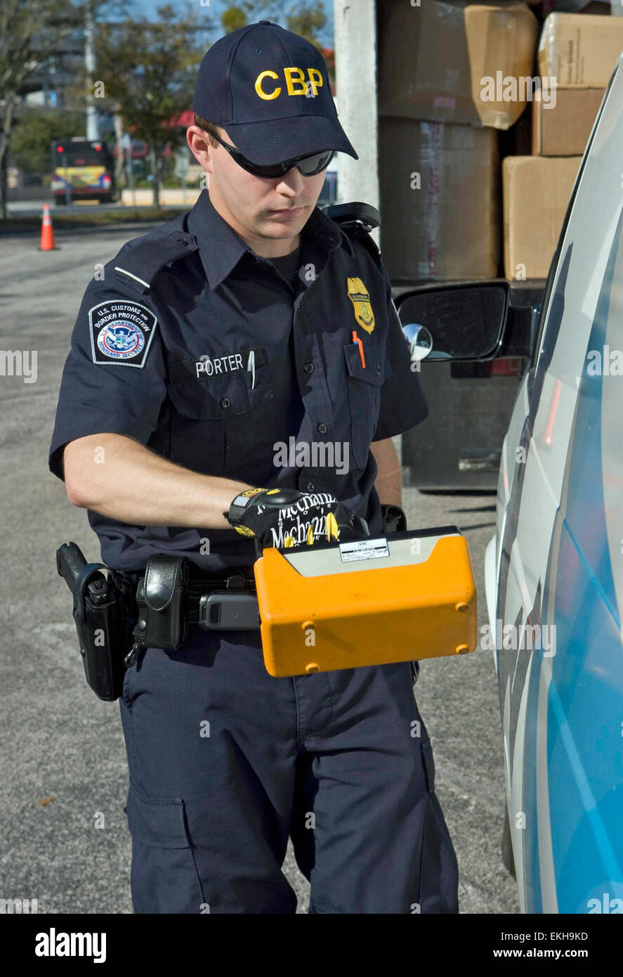 A CBP officer uses a handheld radiation detection unit to screen ...
