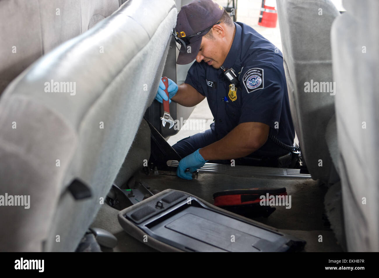 A CBP field operations officer inspects a vehicle entering the U.S. as ...