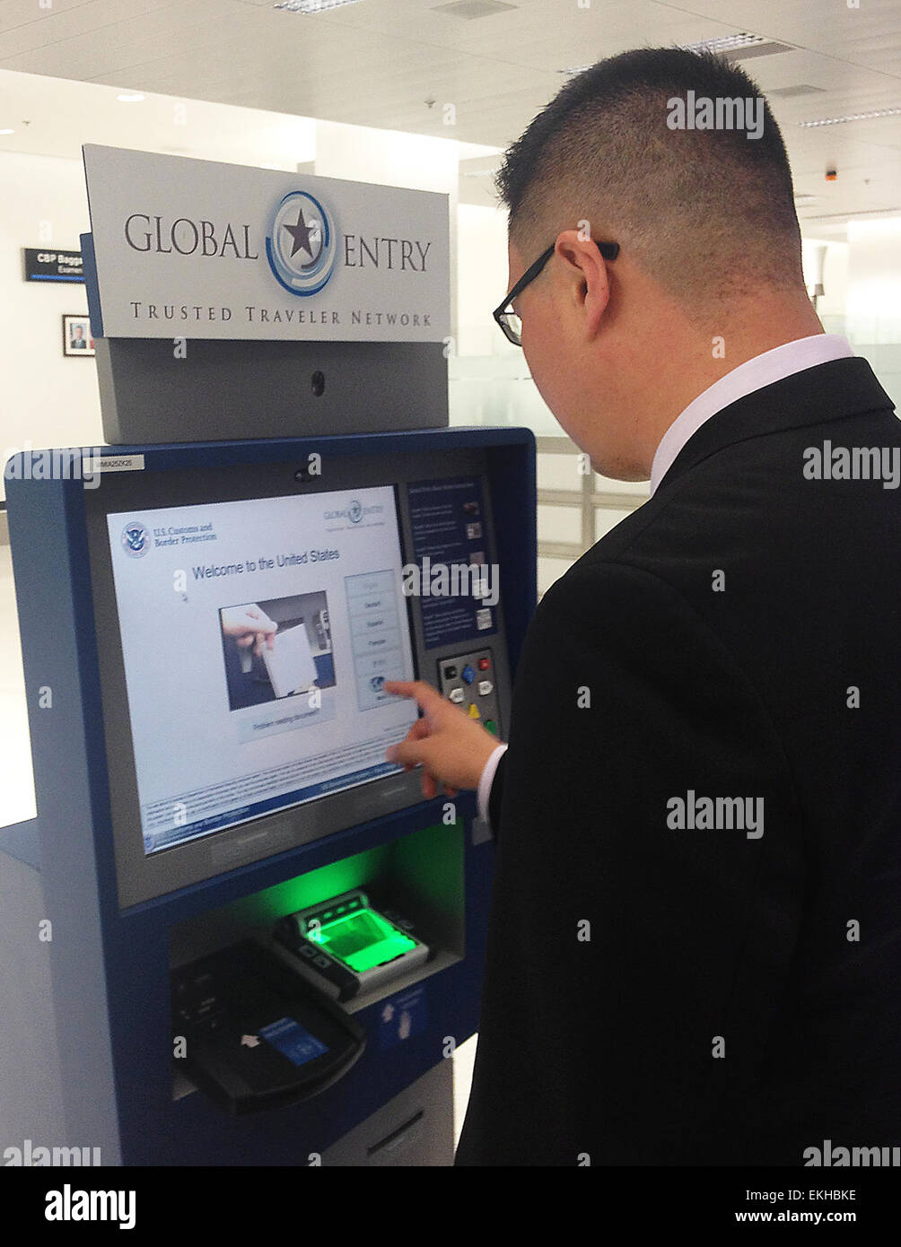 An individual uses a Global Entry kiosk at Miami International Airport ...