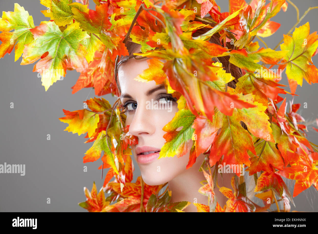 Woman wrapped up in autumn leaves Stock Photo - Alamy